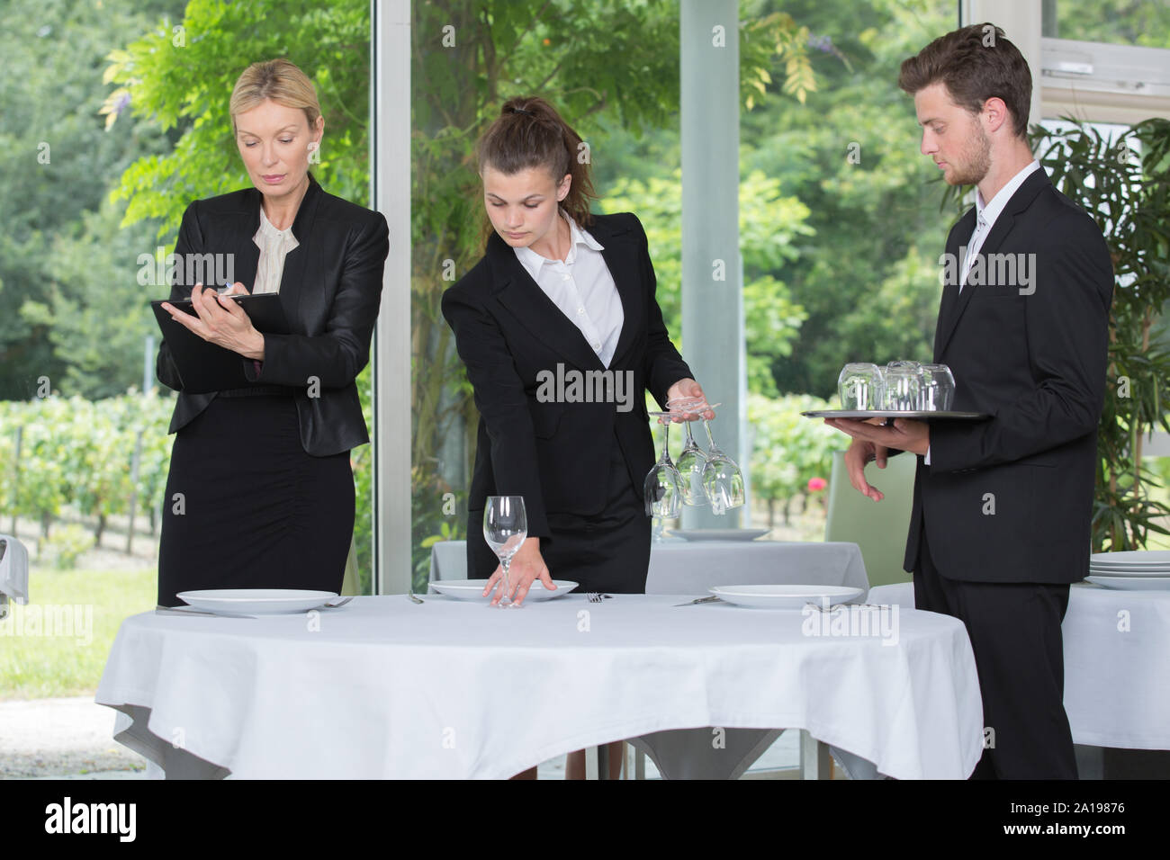 supervisor marking young waiter and waitress Stock Photo - Alamy