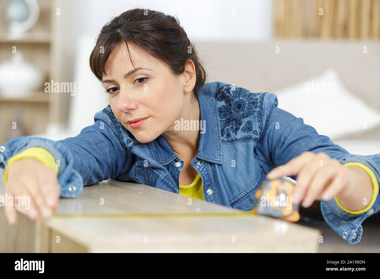 woman measuring a piece of wood Stock Photo - Alamy