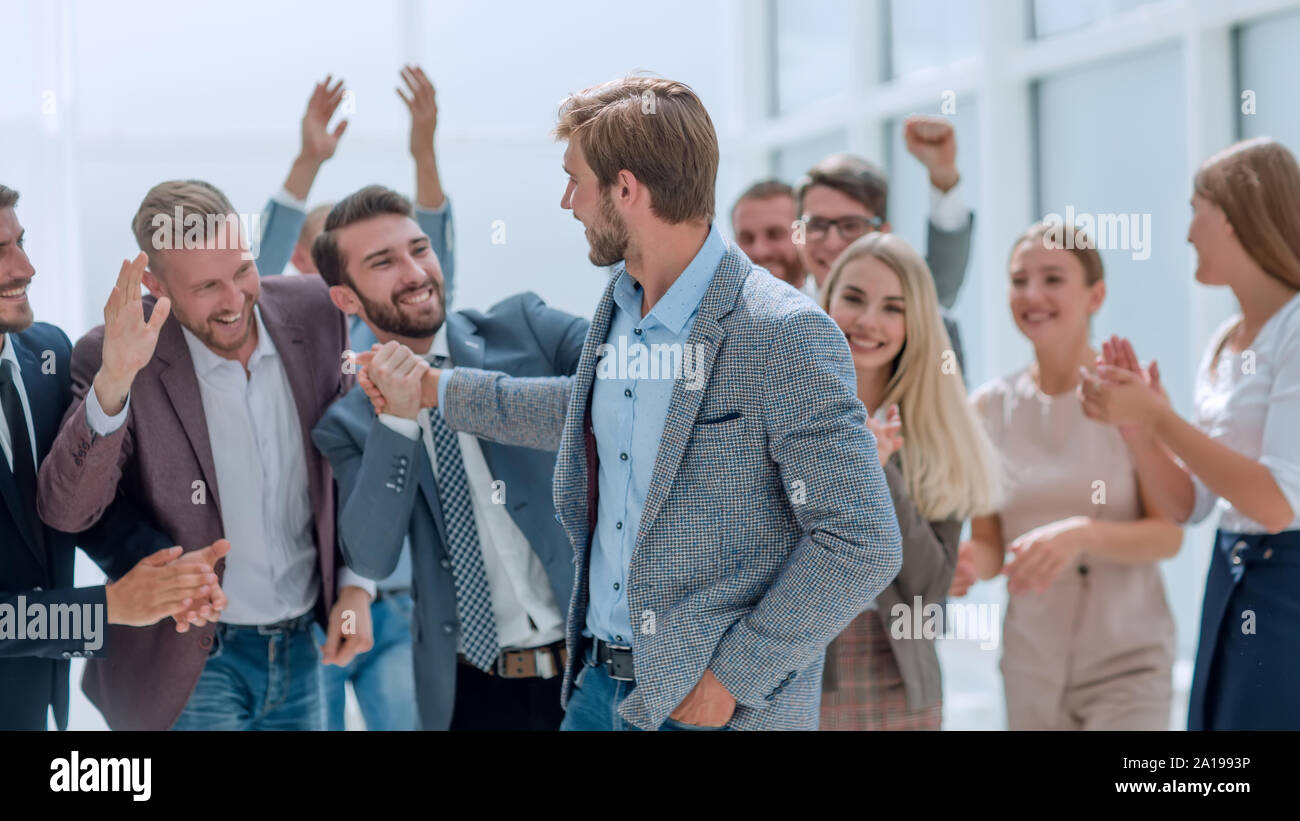 cheerful employees congratulating a colleague on the promotion Stock ...