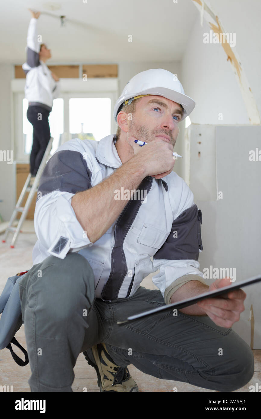 construction worker taking notes on clipboard in a new house Stock ...