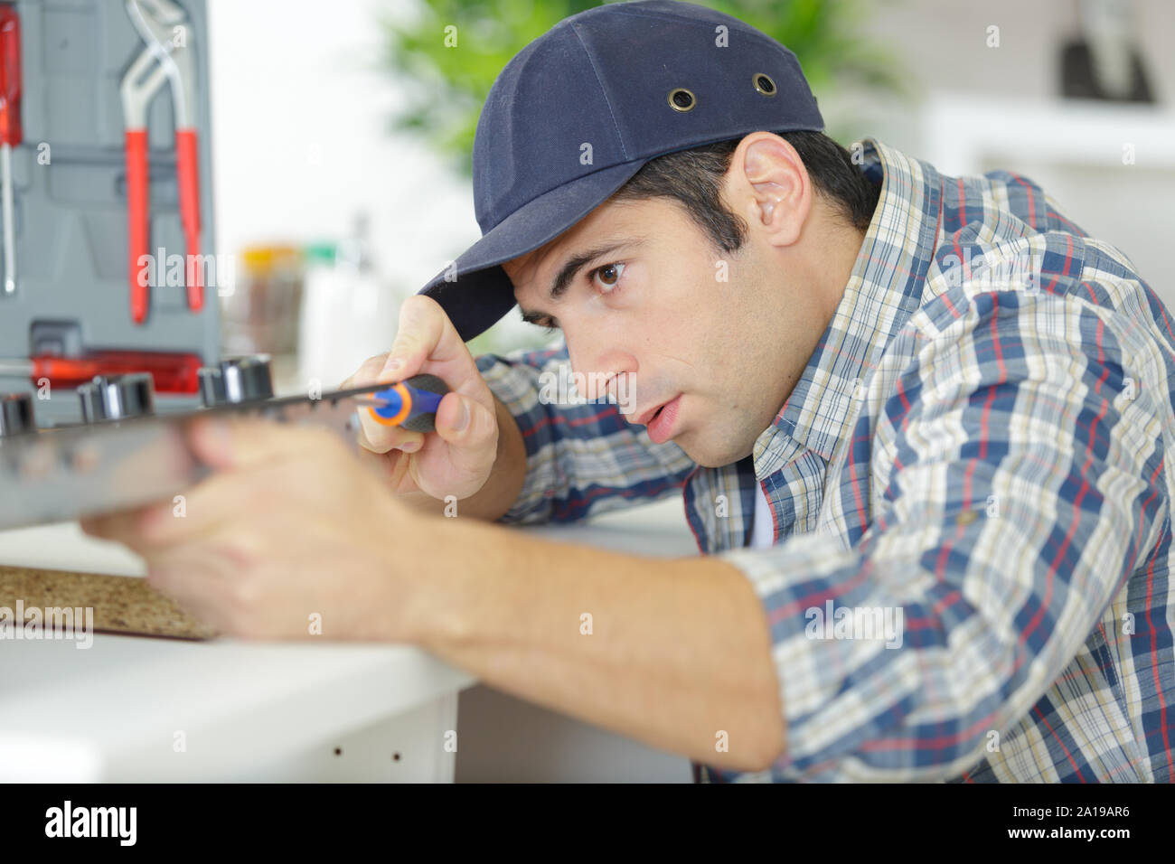 man screwing screws into furniture fittings Stock Photo - Alamy