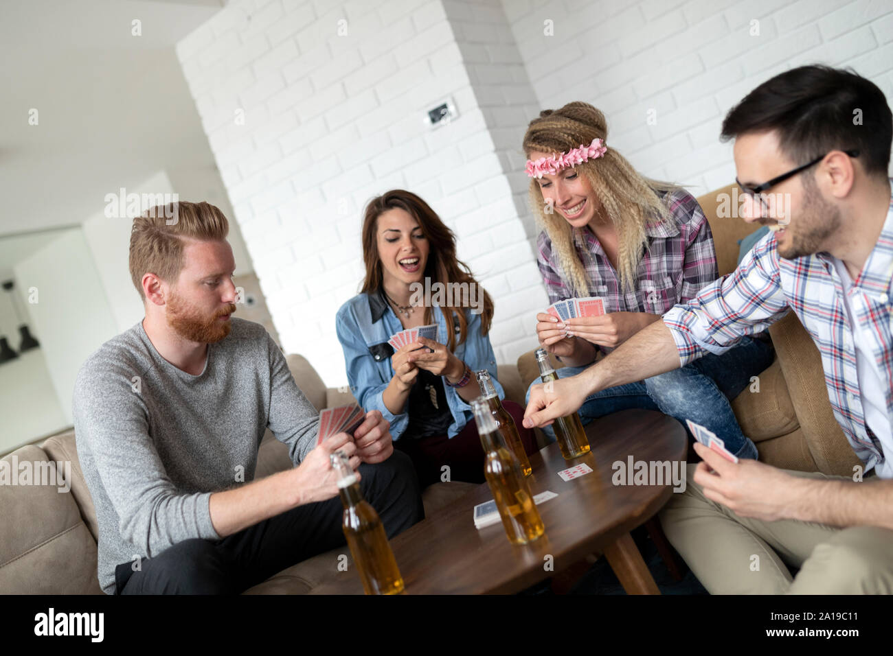 Group of happy friends playing cards and drinking Stock Photo - Alamy