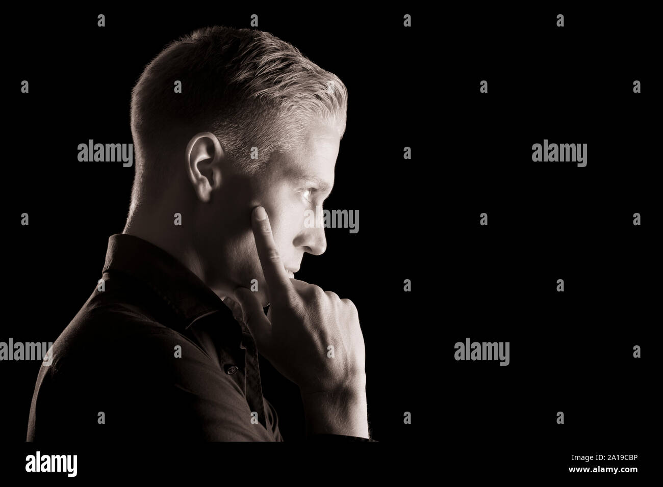 Low key profile portrait of young man, black and white Stock Photo - Alamy