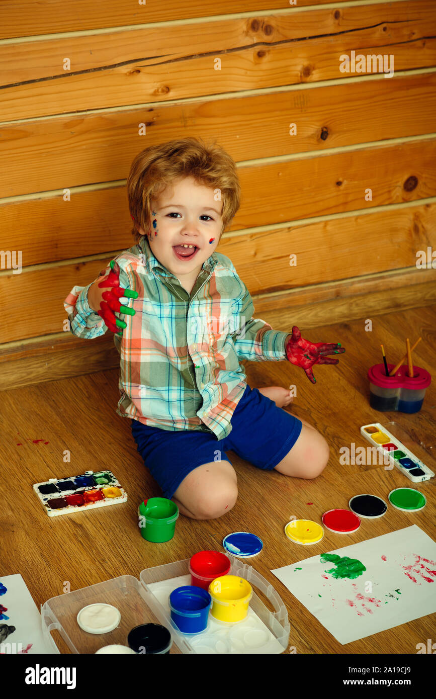 Boy painter painting on wooden floor. Kid learning and playing ...