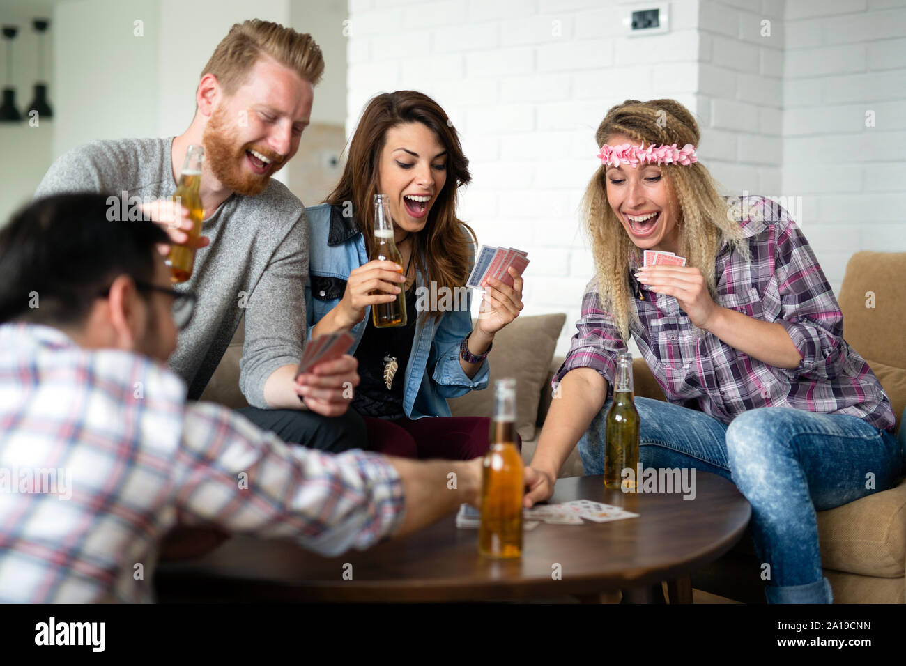 Group of happy friends playing cards and drinking Stock Photo - Alamy