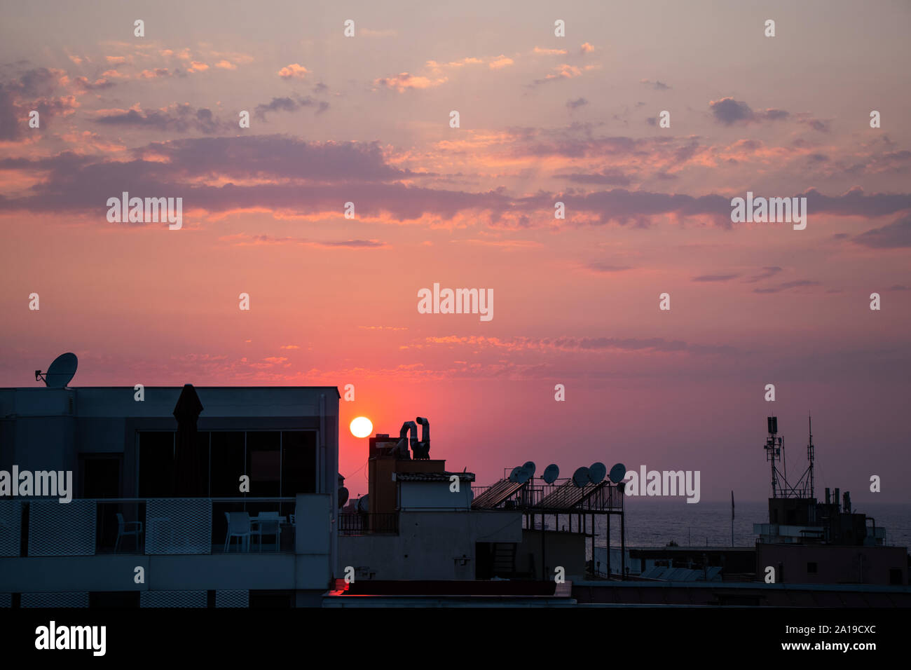 Sun setting behind buildings hi-res stock photography and images - Alamy