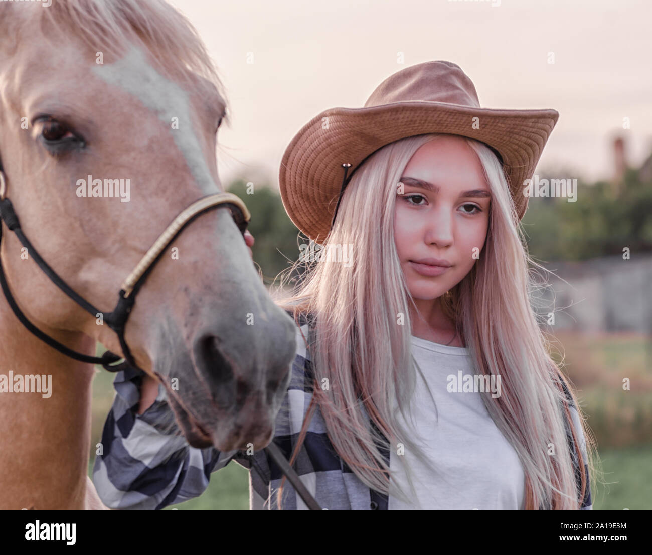 portrait of a young blonde girl dressed in a cowboy hat with a beige ...