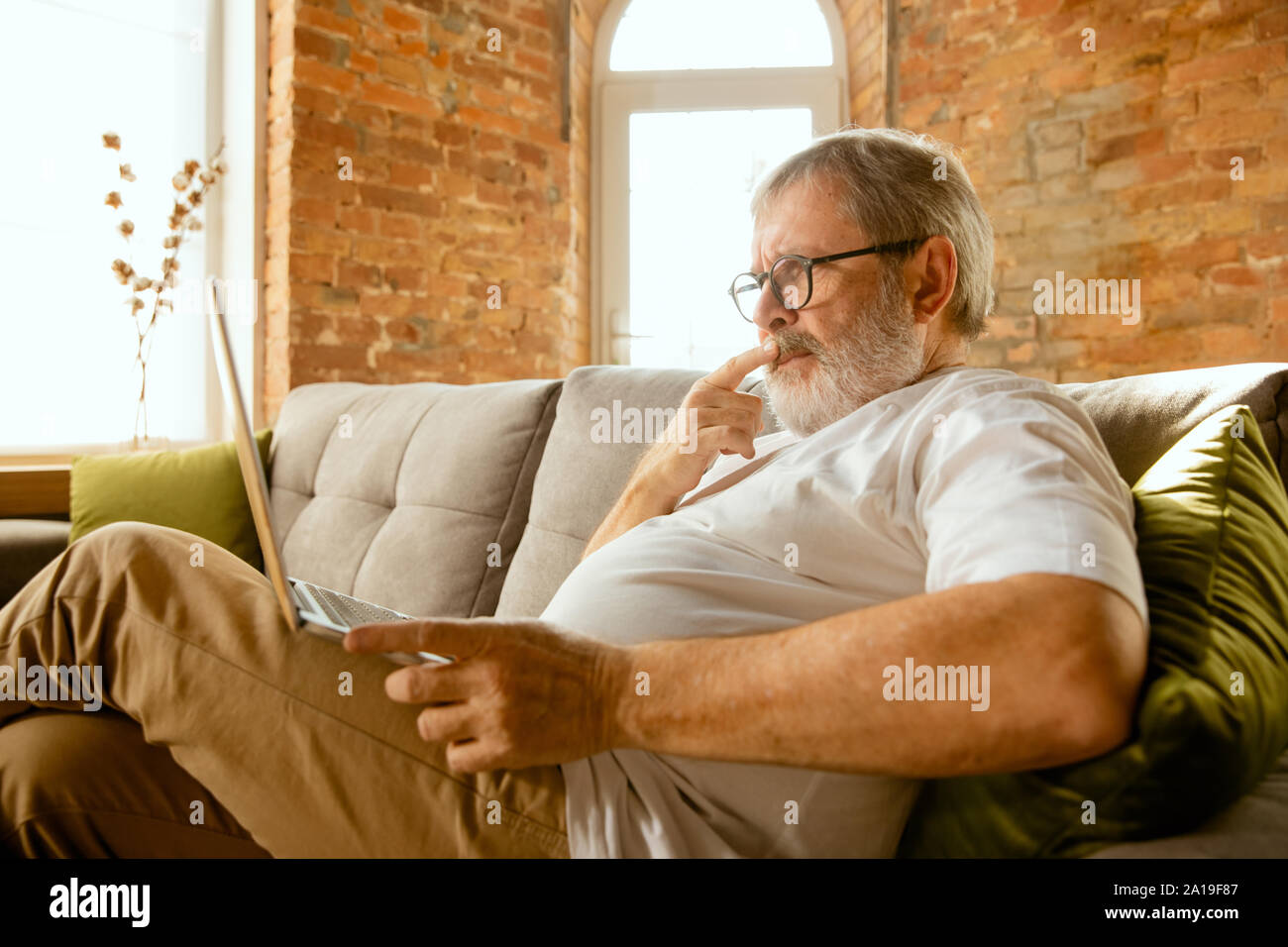 Senior man working with laptop at home - concept of home studying ...