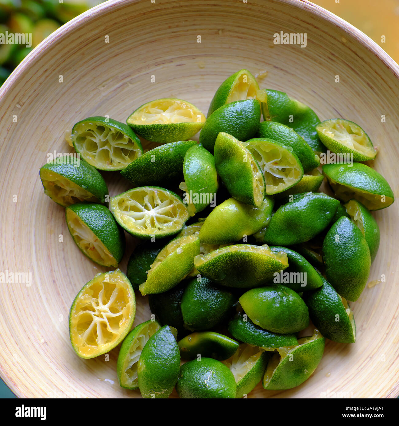 Top view people hand hold kumquat peel in green that squeezed out of ...