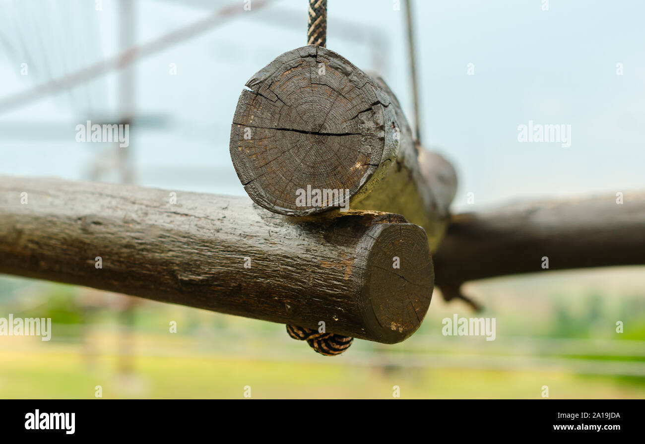 small wooden logs of a suspended rope road close-up against a blue sky ...