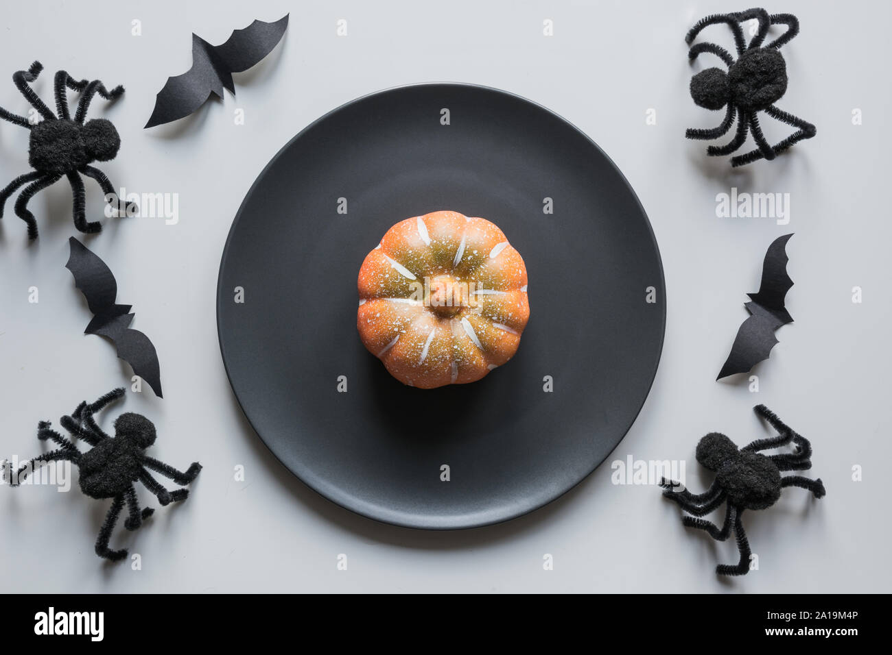 Halloween concept table setting with black spiders, bat, pumpkin on ...
