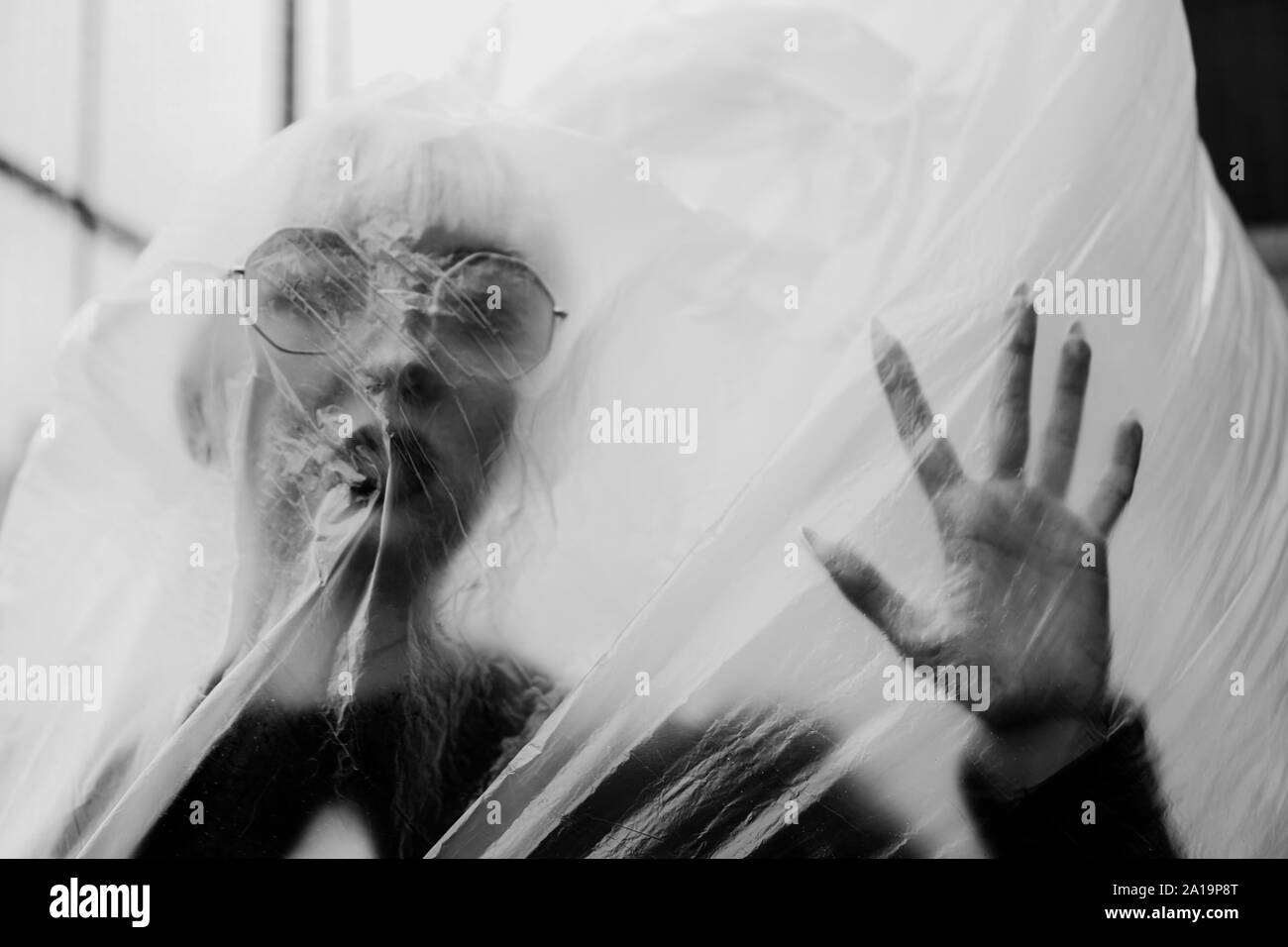 Ecology concept. Girl with plastic wrap Hand raised. City Style. Urban ...