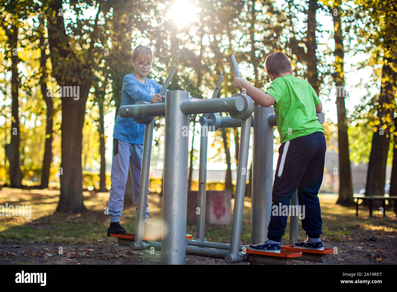 Two boys do workout on trainer equipment outdoor. Children, activity ...