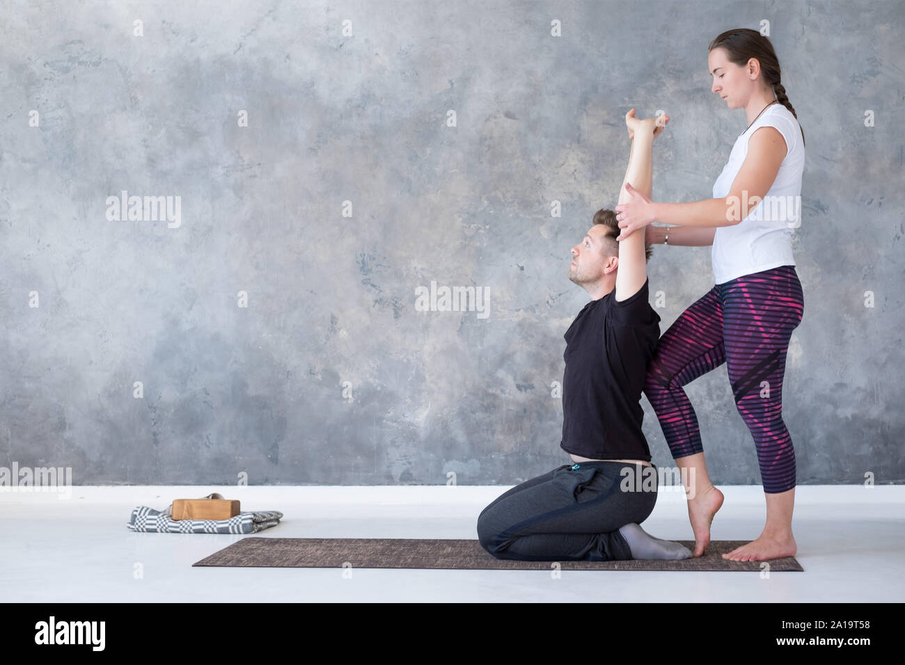 Yoga instructor helping her student to stretch muscles. Wellbeing ...