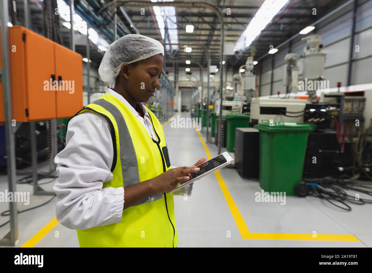 Female factory worker in a large factory warehouse Stock Photo - Alamy
