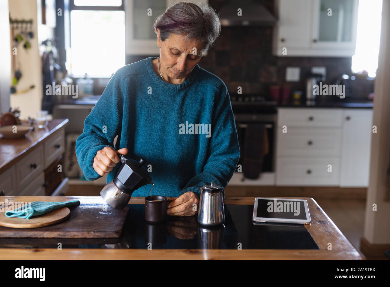 Senior woman making coffee Stock Photo - Alamy