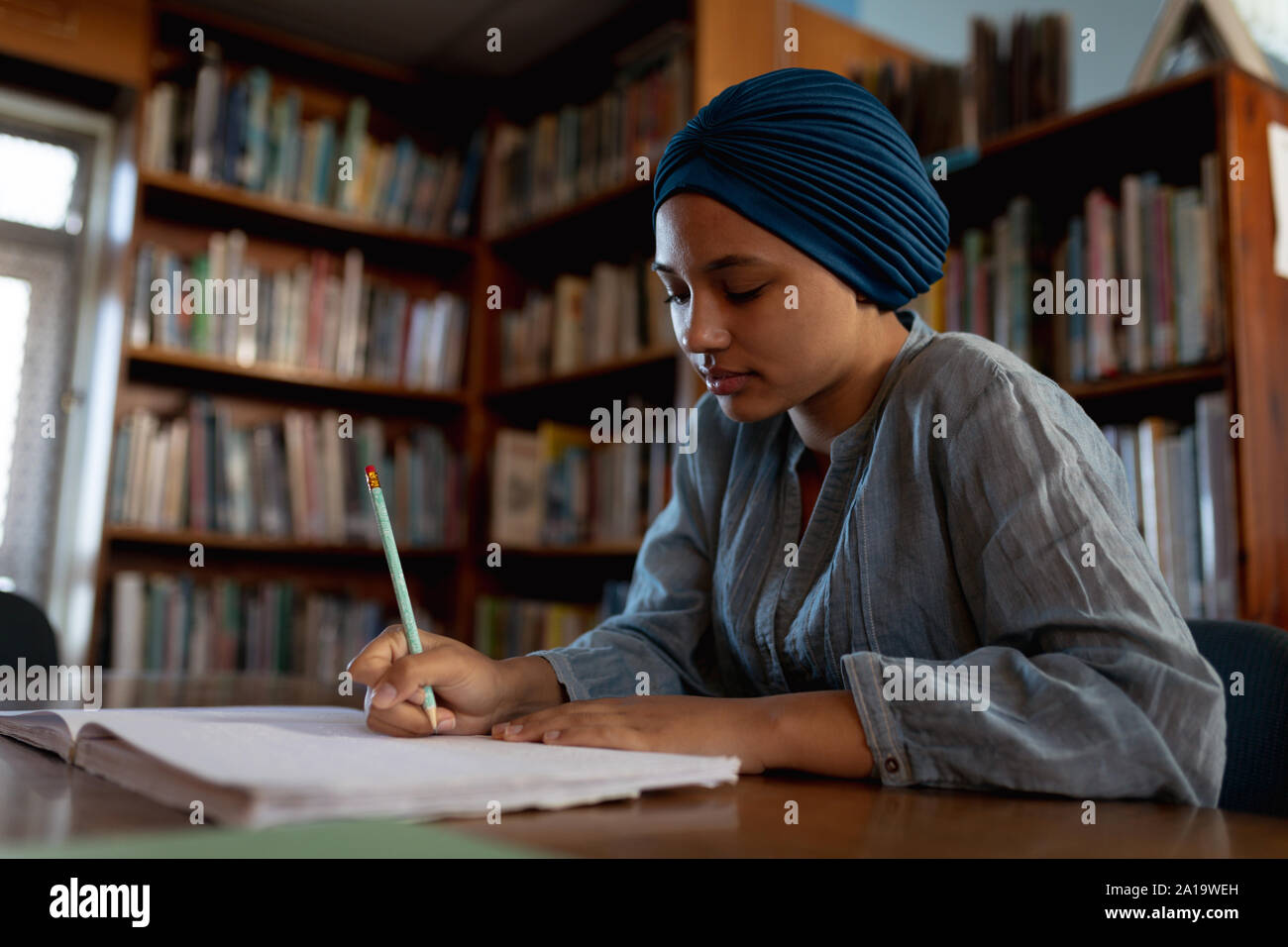 Young woman studying in library Stock Photo - Alamy