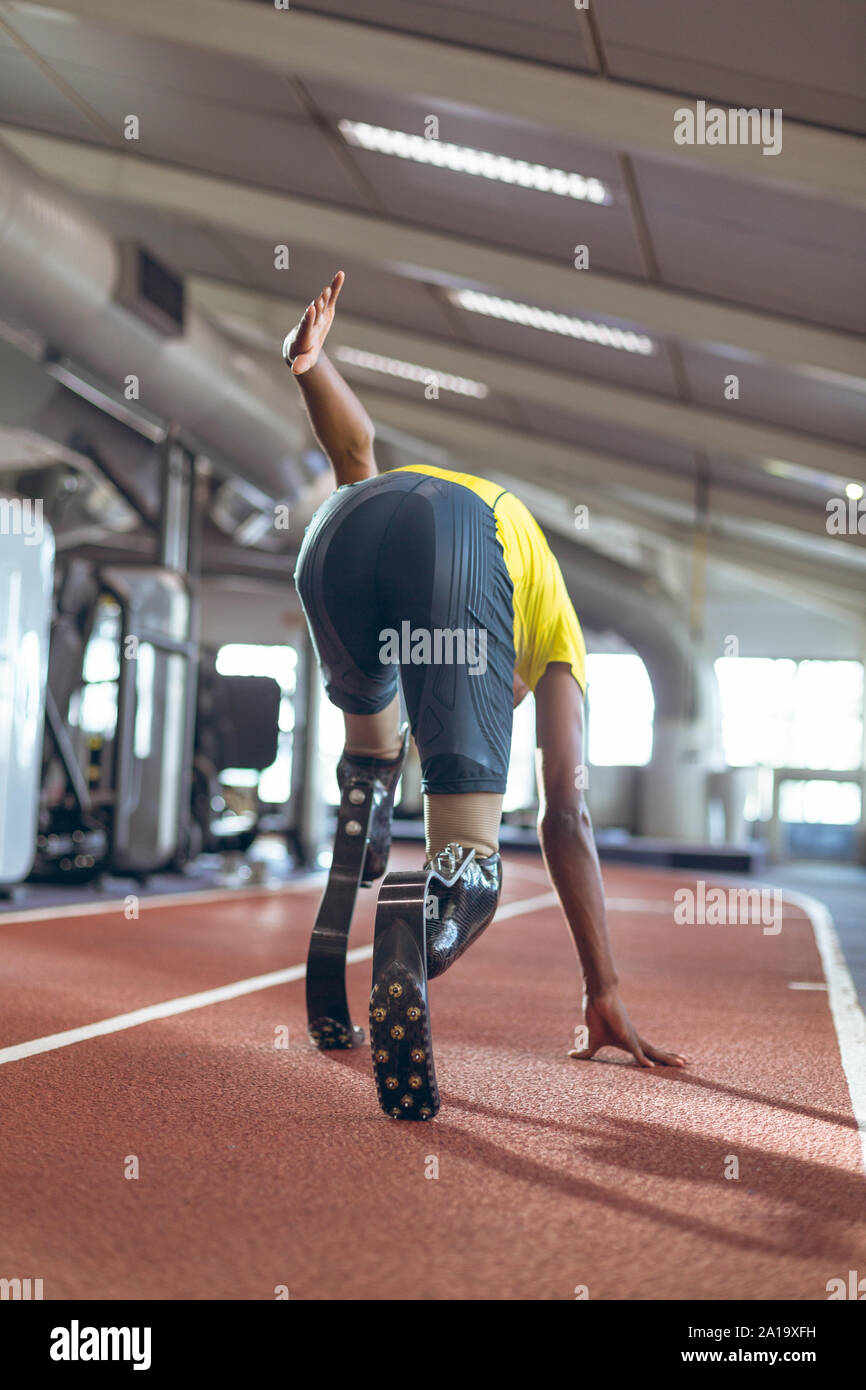Disabled male athletic running on sports track in fitness center Stock ...