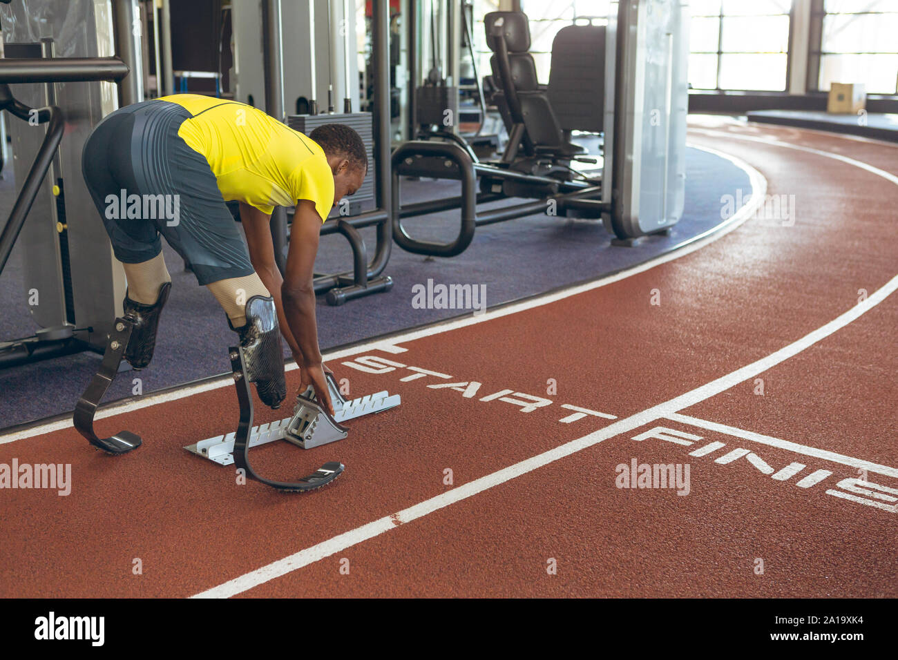Disabled African American male athletic at starting block on running ...