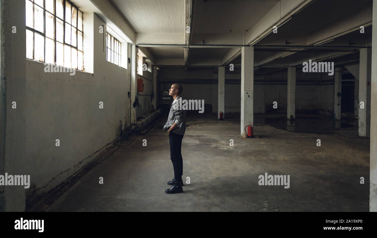 Young man inside an empty warehouse Stock Photo - Alamy