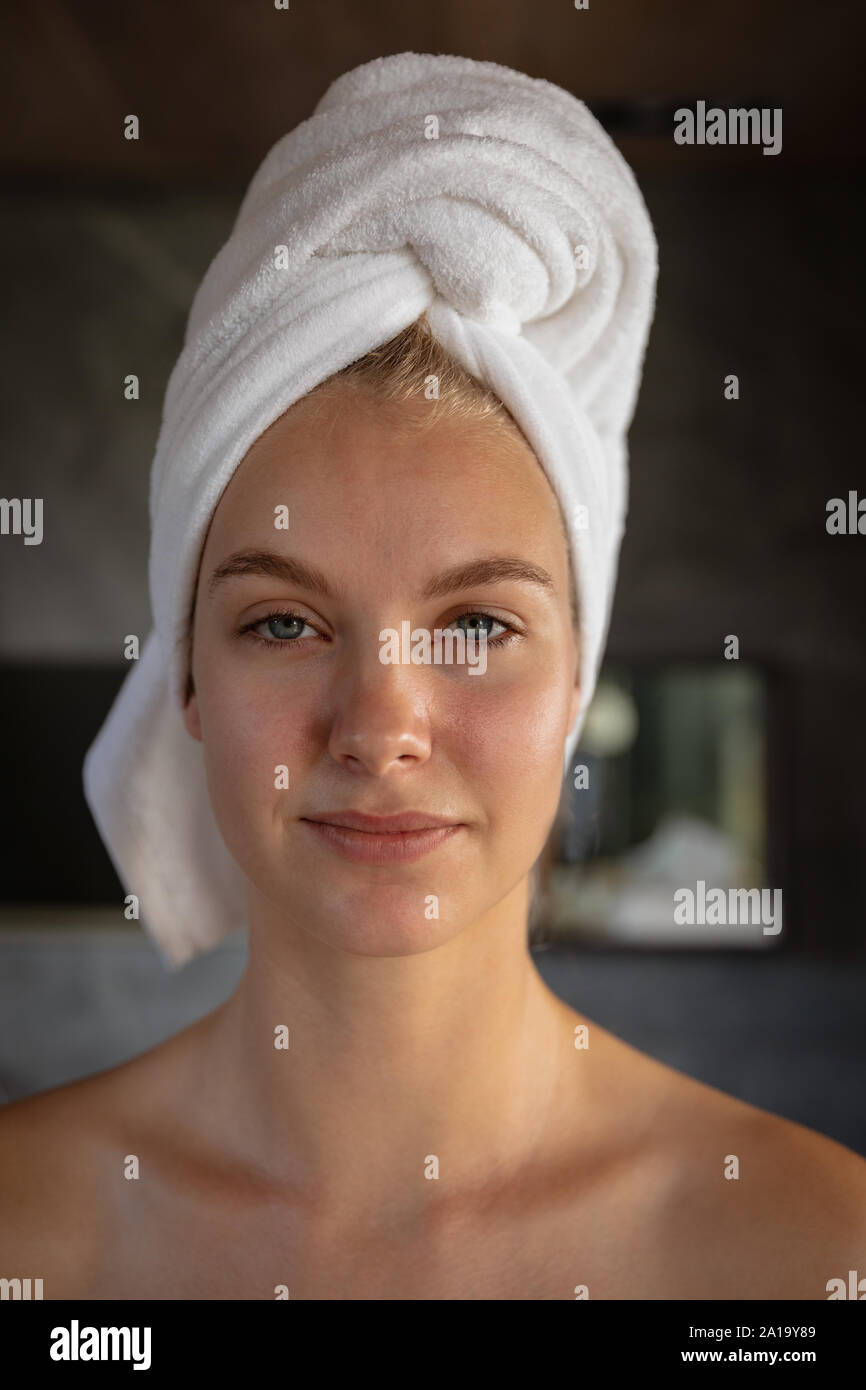 Young Blonde Woman In A Hotel Bathroom With Her Hair Wrapped In A Towel