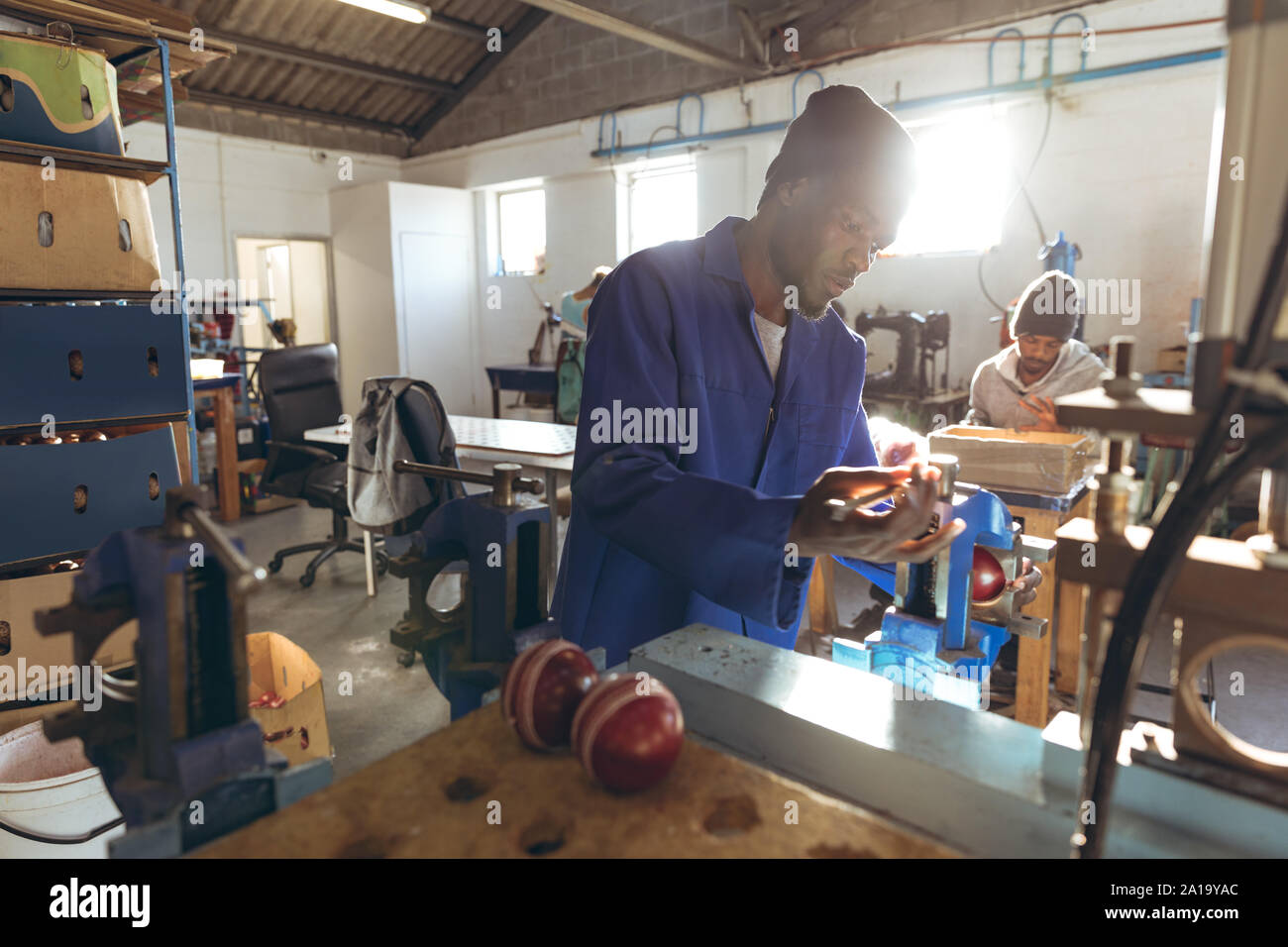 Young man working in a sports equipment factory Stock Photo - Alamy