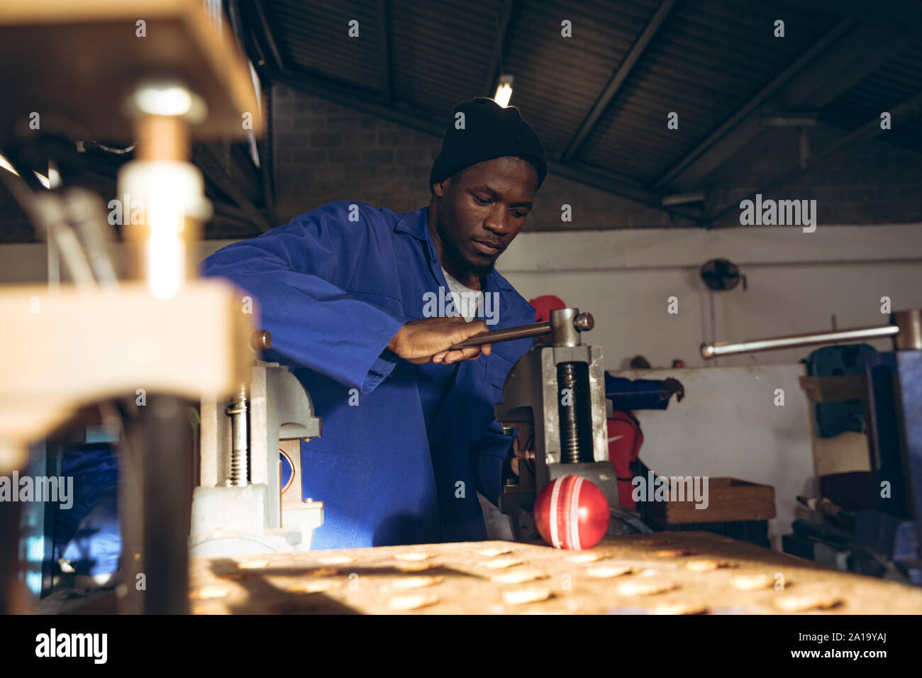 Young man working in a sports equipment factory Stock Photo - Alamy