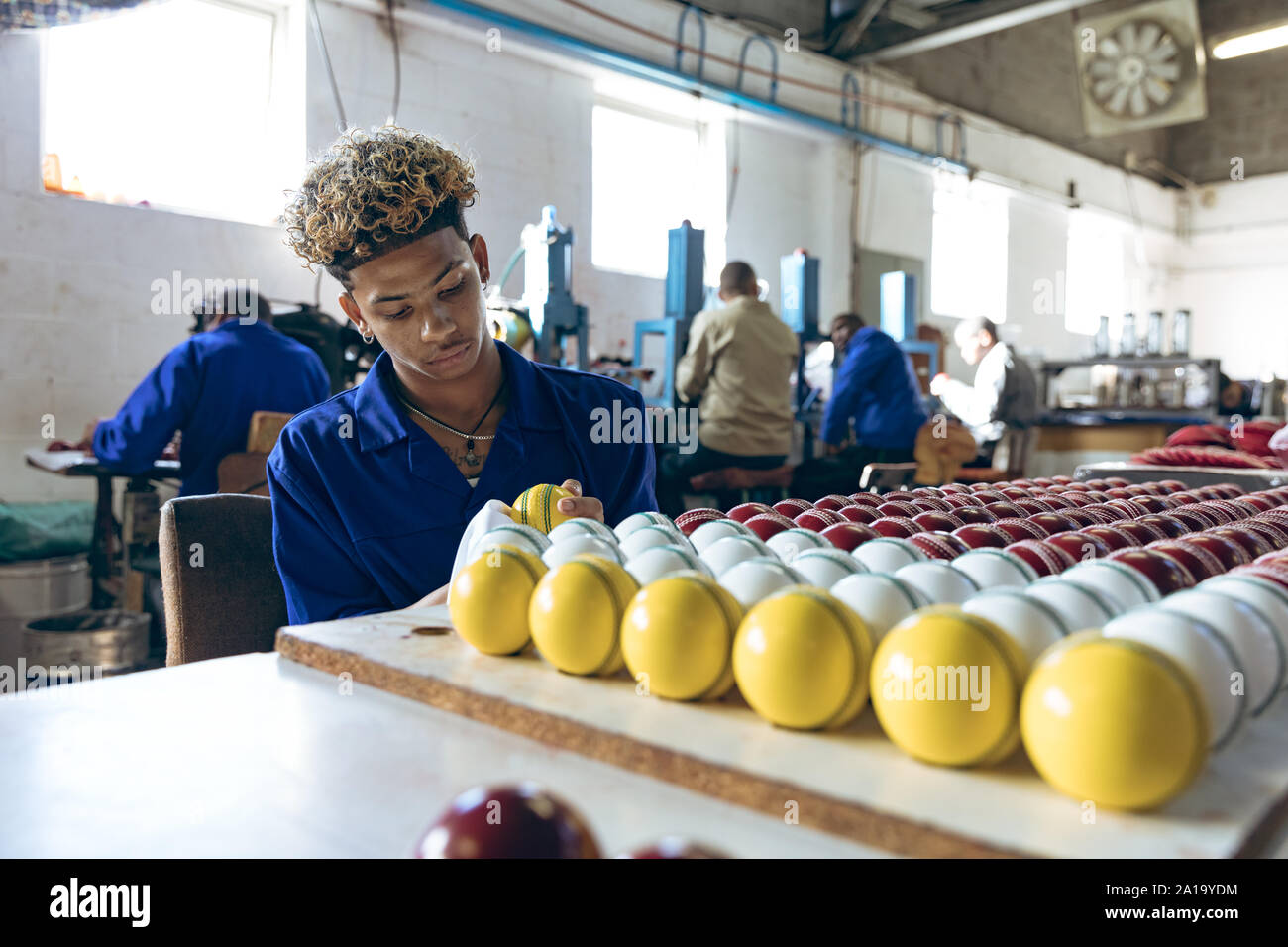 Young man working in a sports equipment factory Stock Photo - Alamy