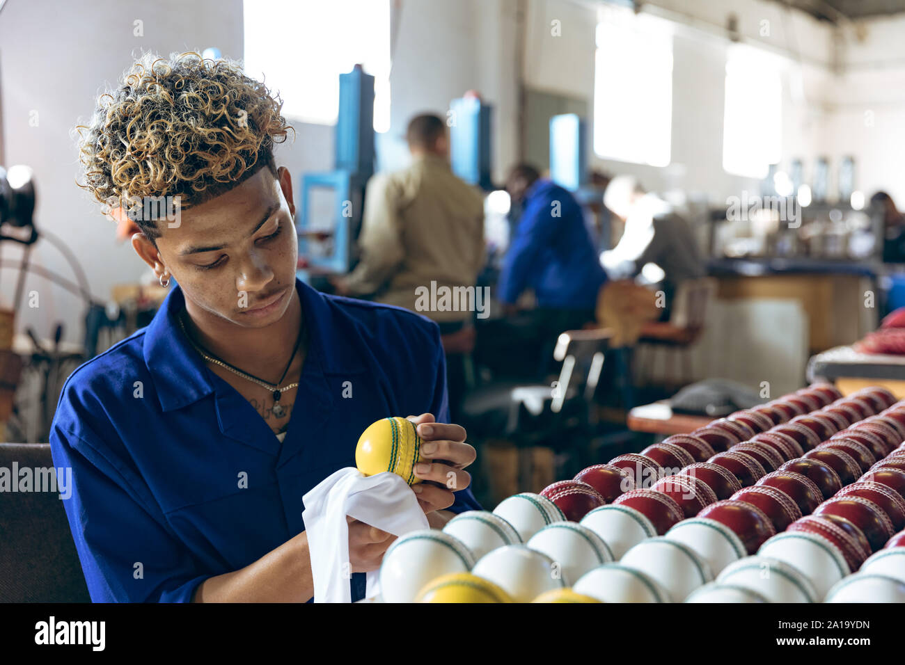 Young man working in a sports equipment factory Stock Photo - Alamy