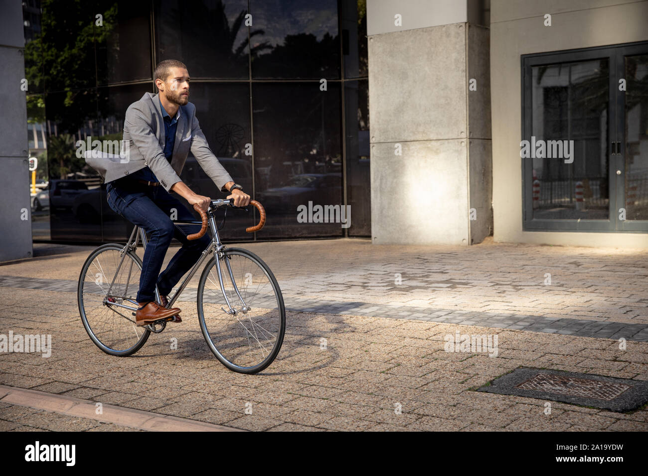Young professional man riding a bike in a city Stock Photo - Alamy