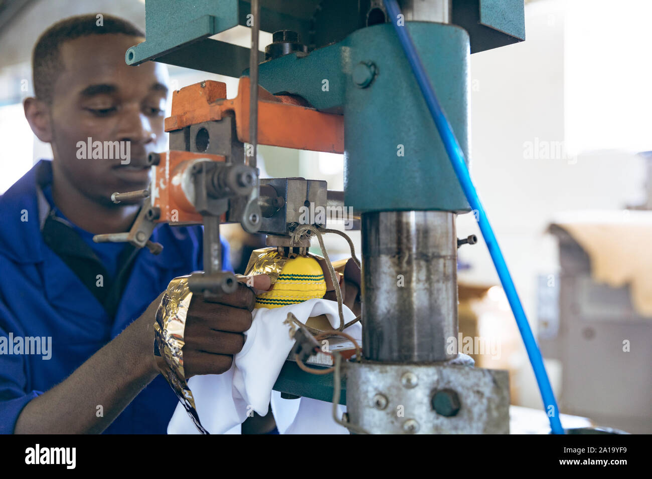 Young man working in a sports equipment factory Stock Photo - Alamy