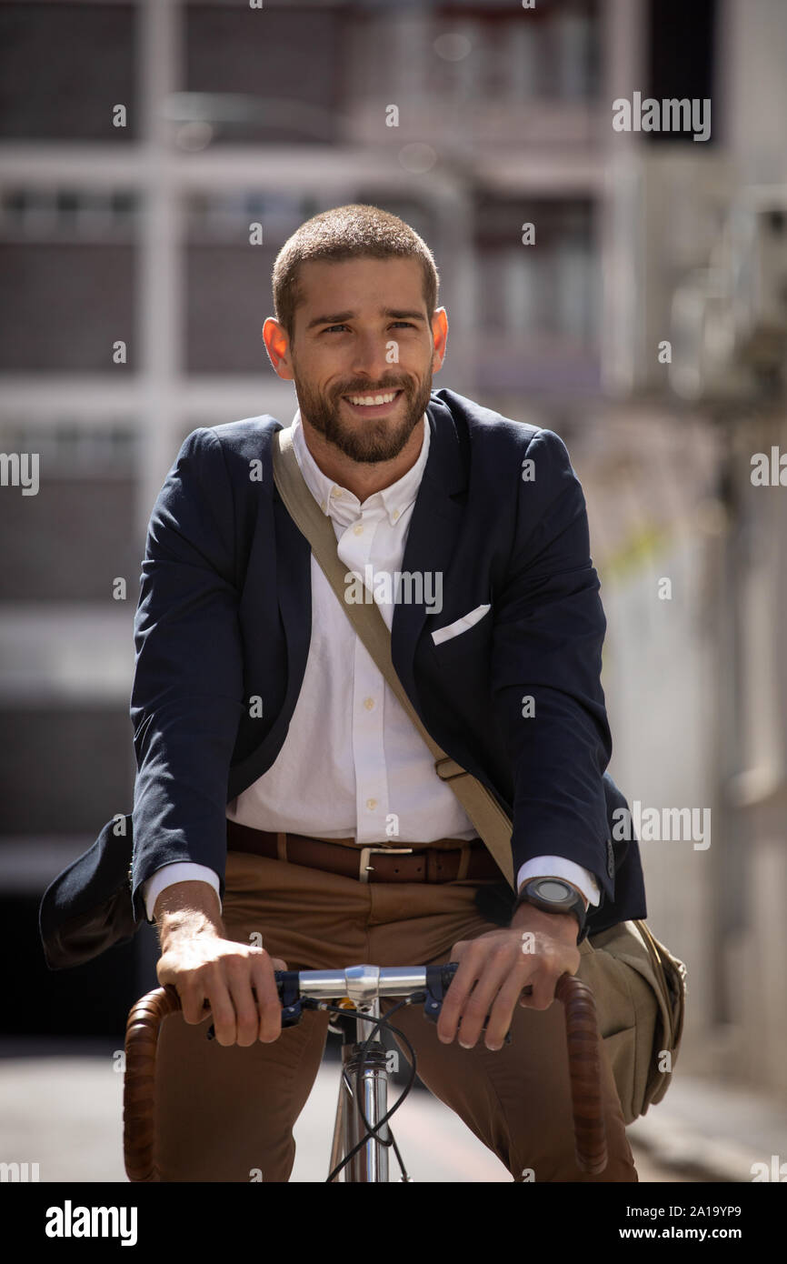 Young professional man riding a bike in a city Stock Photo - Alamy