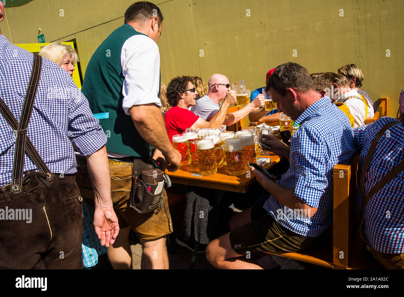 Munich,Germany-September 21,2019: People toast at a table while a ...