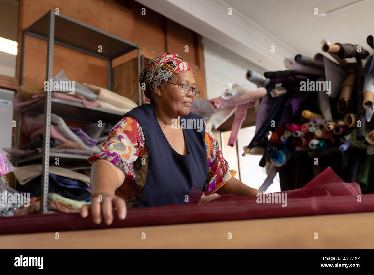 Middle aged woman working at a hat factory Stock Photo - Alamy