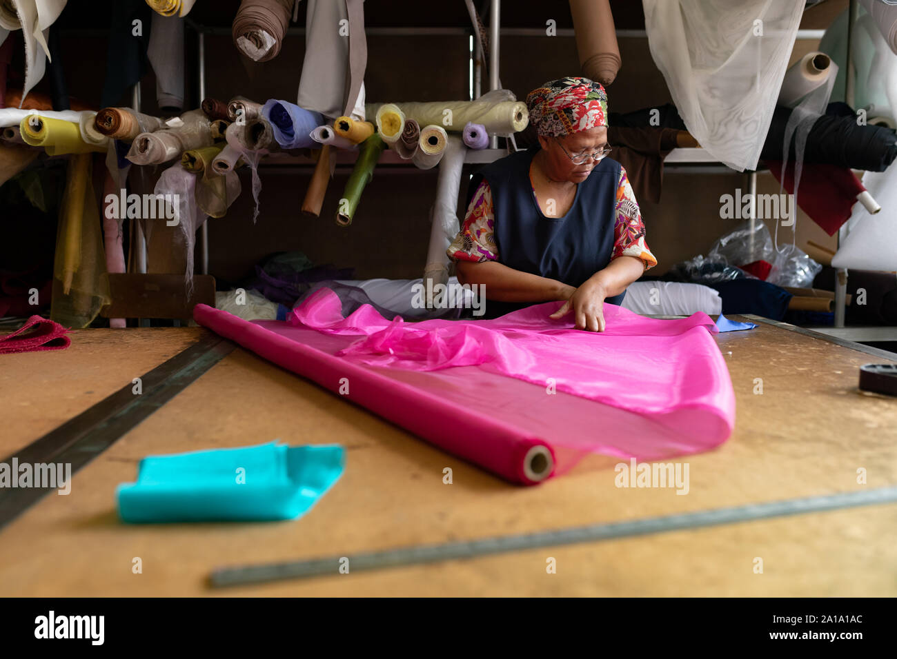Middle aged woman working at a hat factory Stock Photo - Alamy