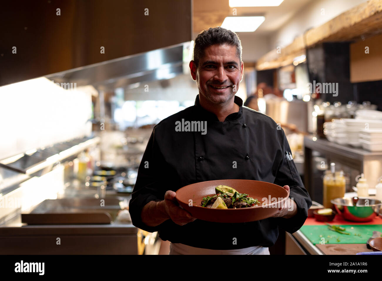 Portrait of chef holding a dish in restaurant kicthen Stock Photo - Alamy
