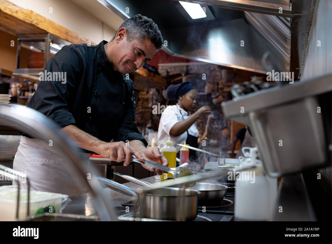 Chefs working in busy restaurant kitchen Stock Photo - Alamy