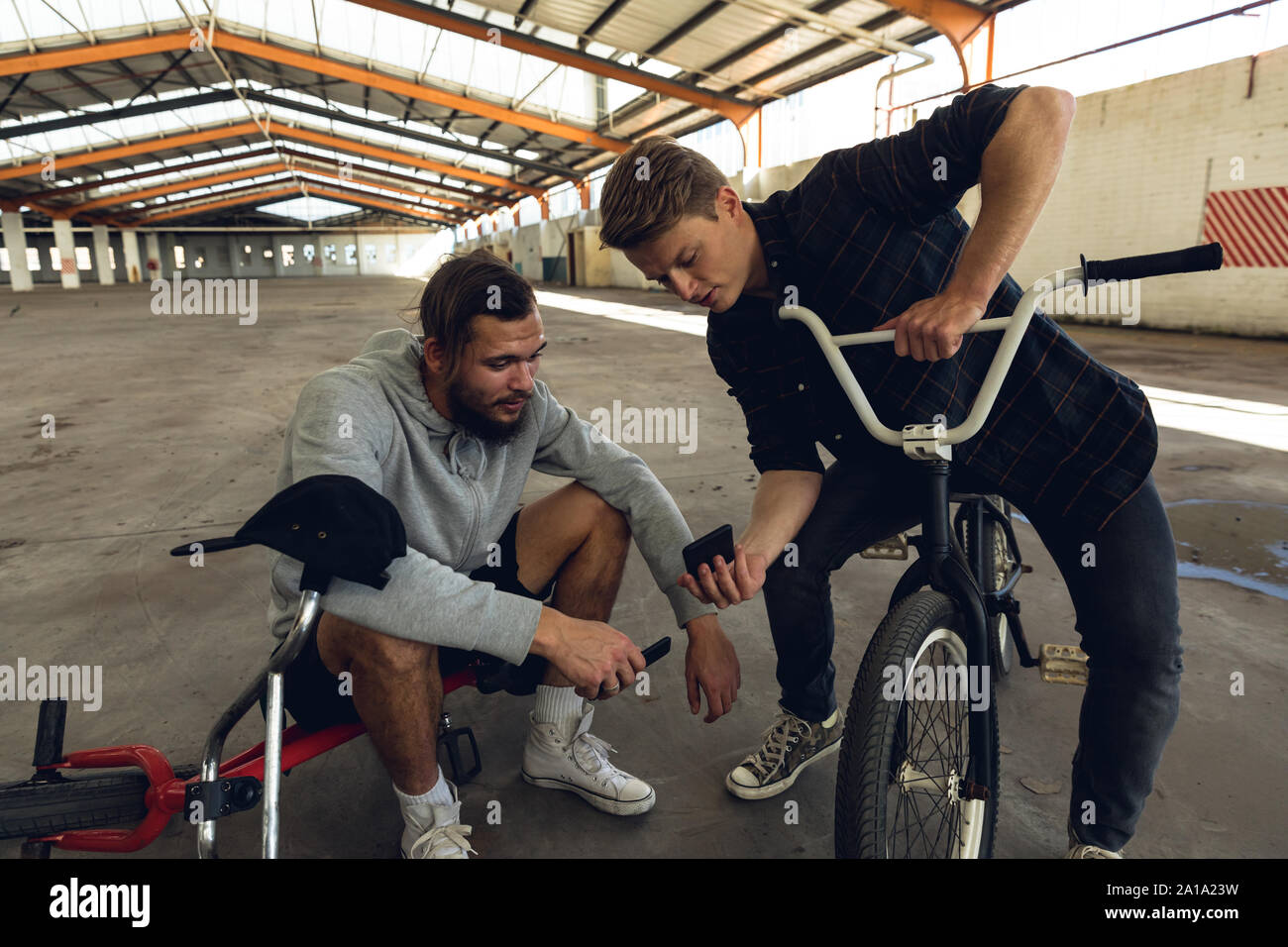 BMX riders in an empty warehouse Stock Photo - Alamy