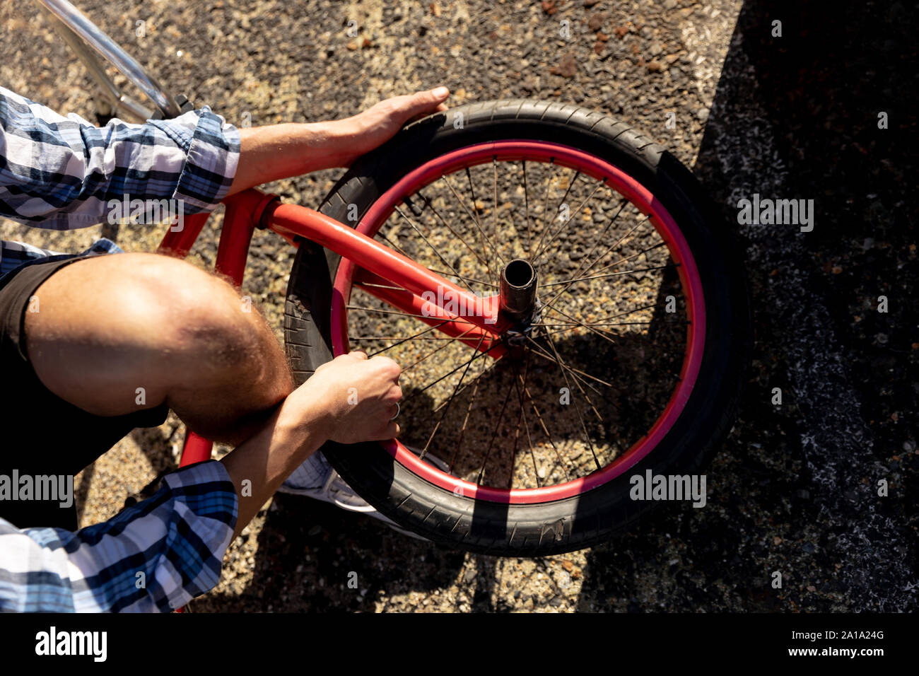 BMX rider repairing wheel Stock Photo - Alamy