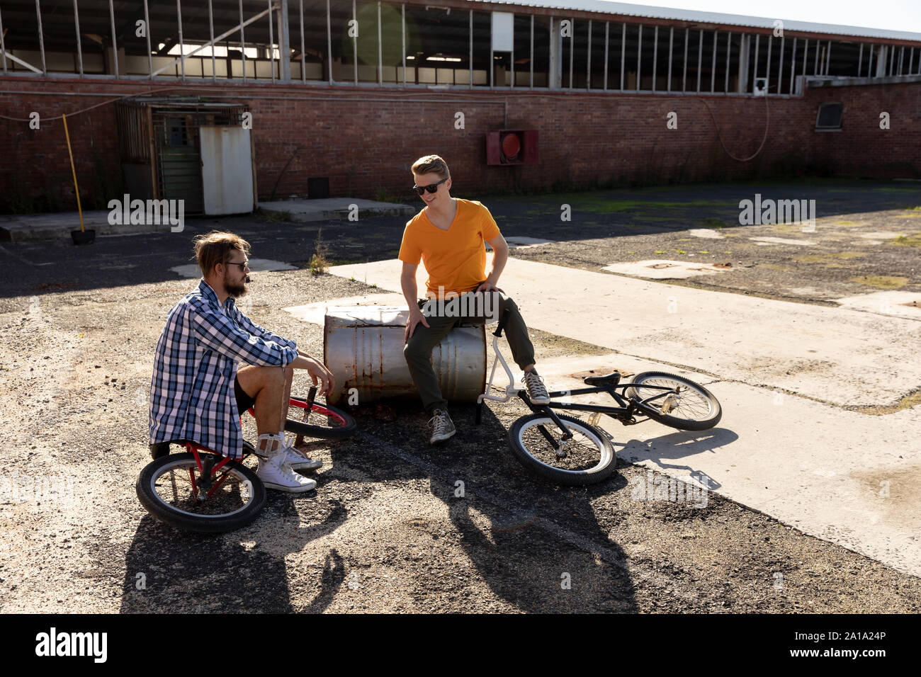 BMX riders sitting in a yard talking Stock Photo - Alamy