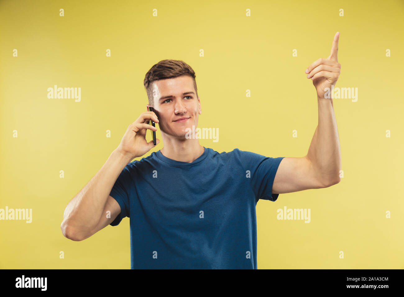 Caucasian young man's half-length portrait on yellow studio background ...