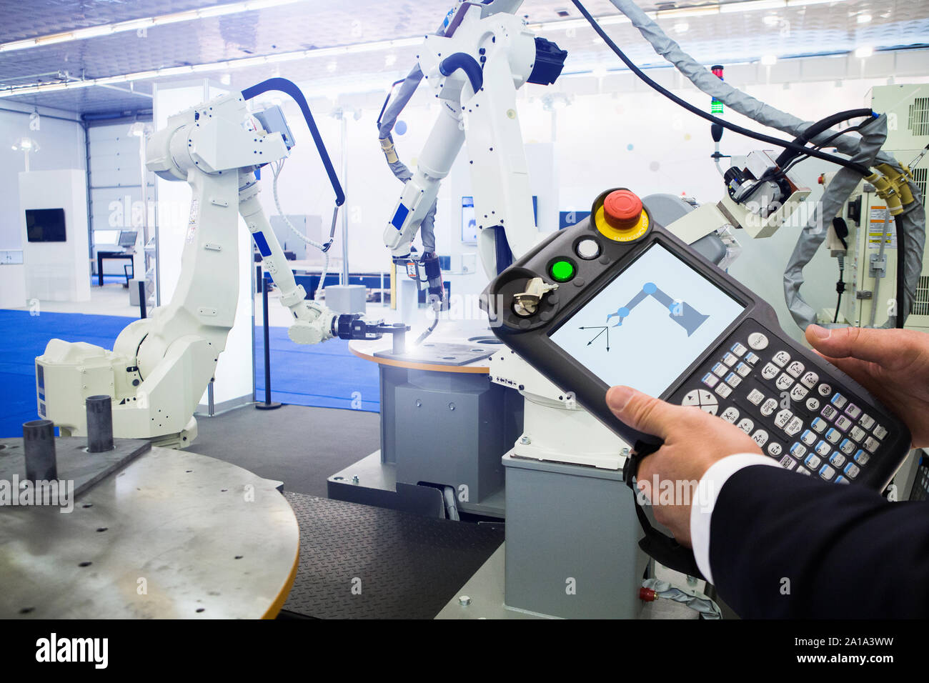 Engineer with teach pendant device. Programming robot with robotic arm ...