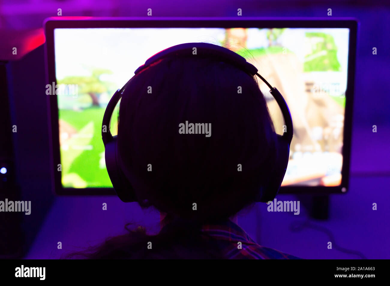 Female gamer in earphones playing on networks in video games Stock ...