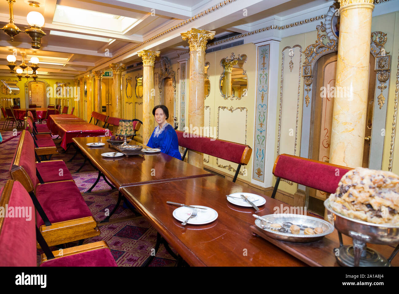 Mannequin model figure in period costume sitting at the long dining ...