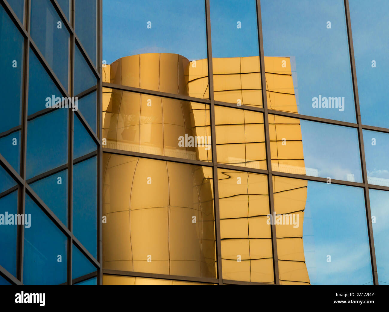 distorted reflection of a yellow building in the mirrored windows of an ...