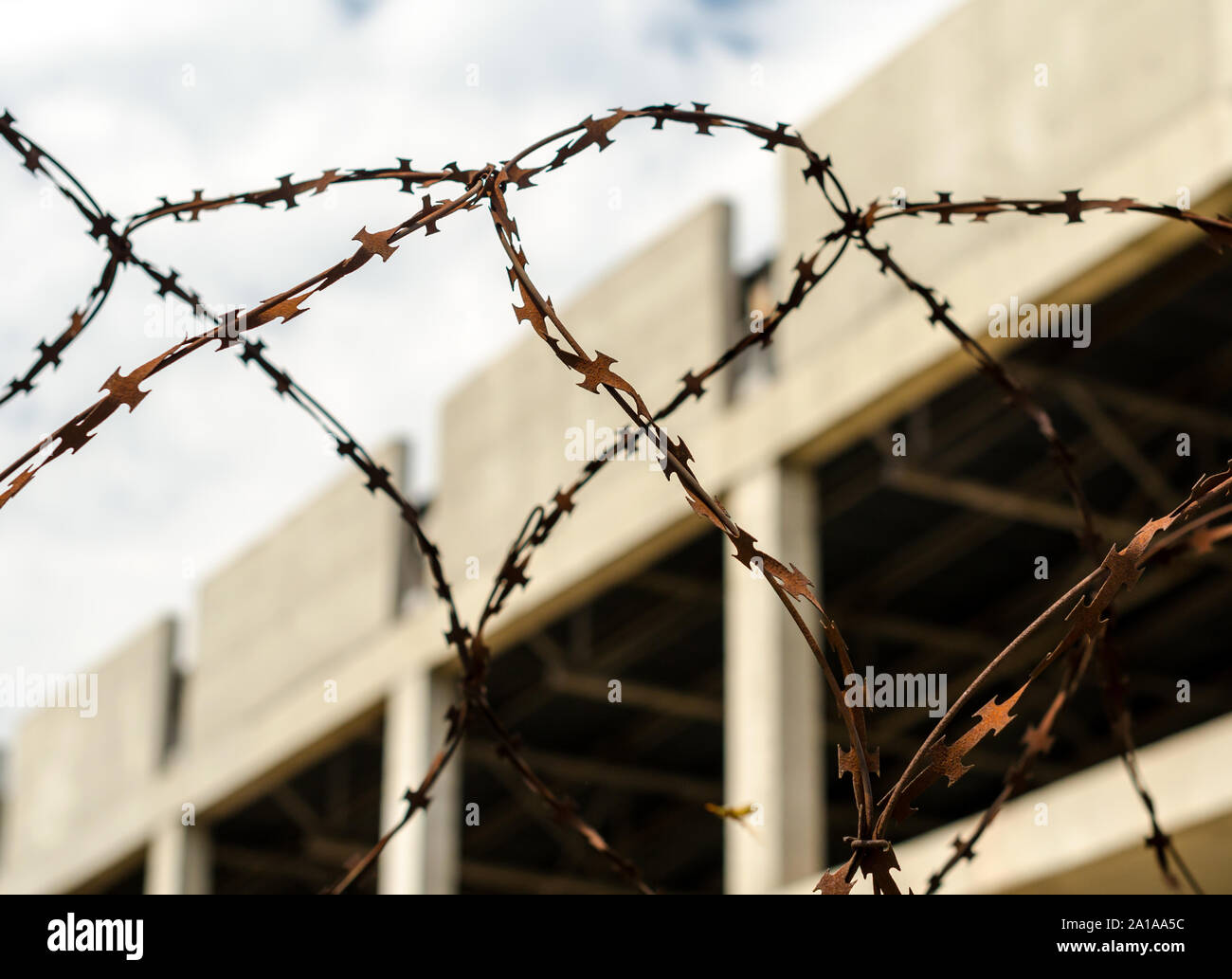 old rusty barbed wire fence against the backdrop of an abandoned ...