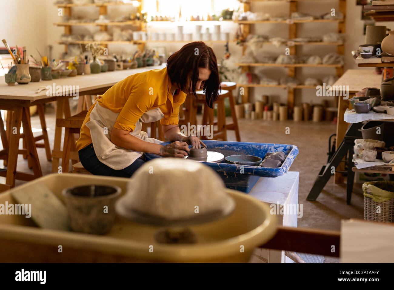 Female potter in a pottery studio using pottery wheel Stock Photo - Alamy