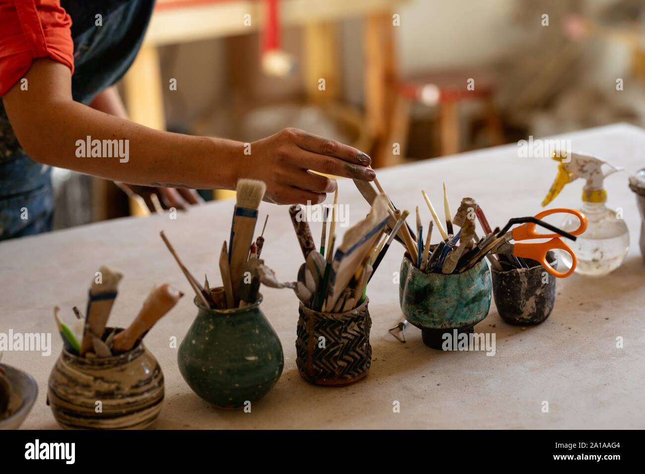 Female potter in a pottery studio choosing tools Stock Photo - Alamy