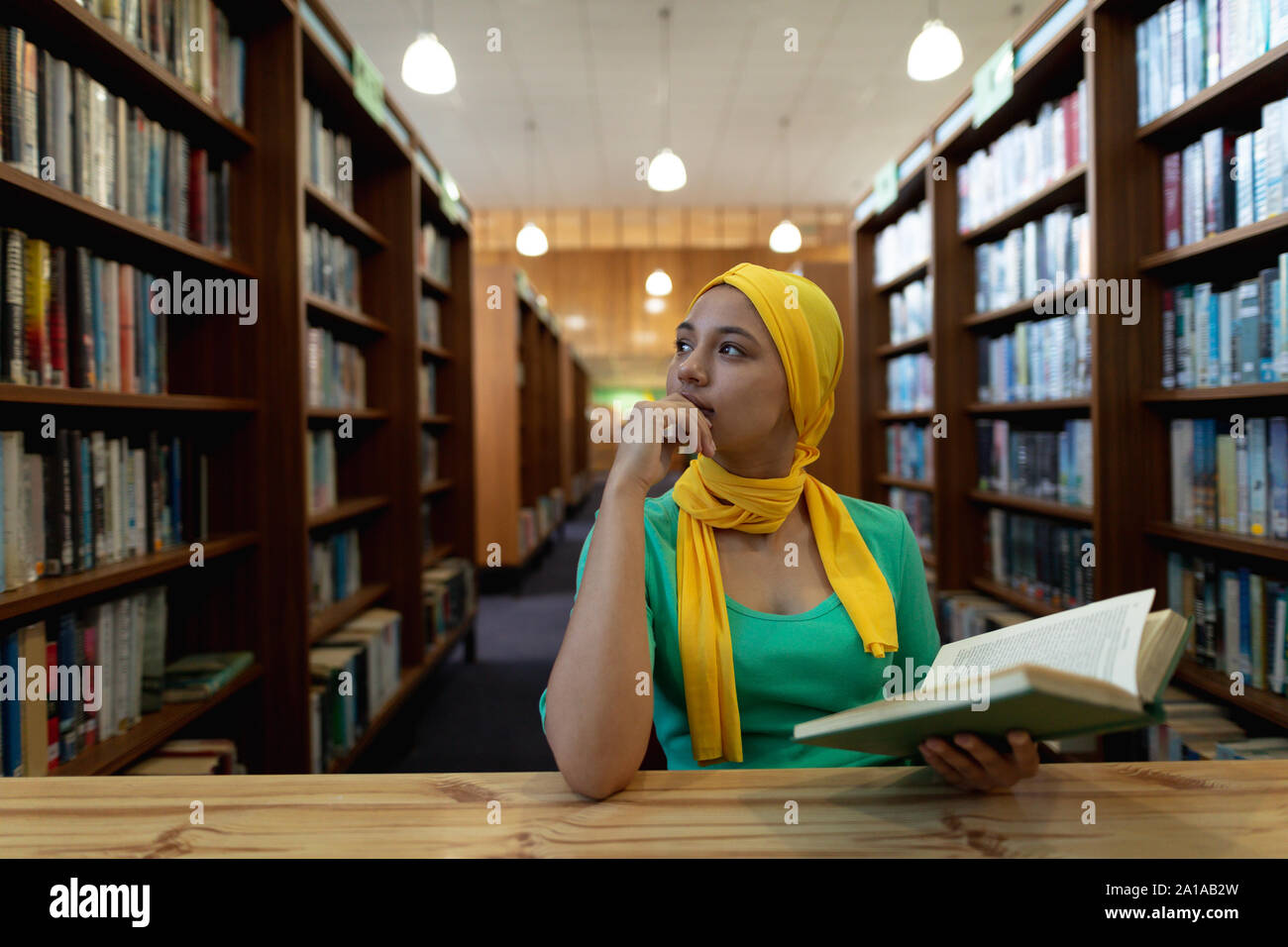 Young woman studying in library Stock Photo - Alamy