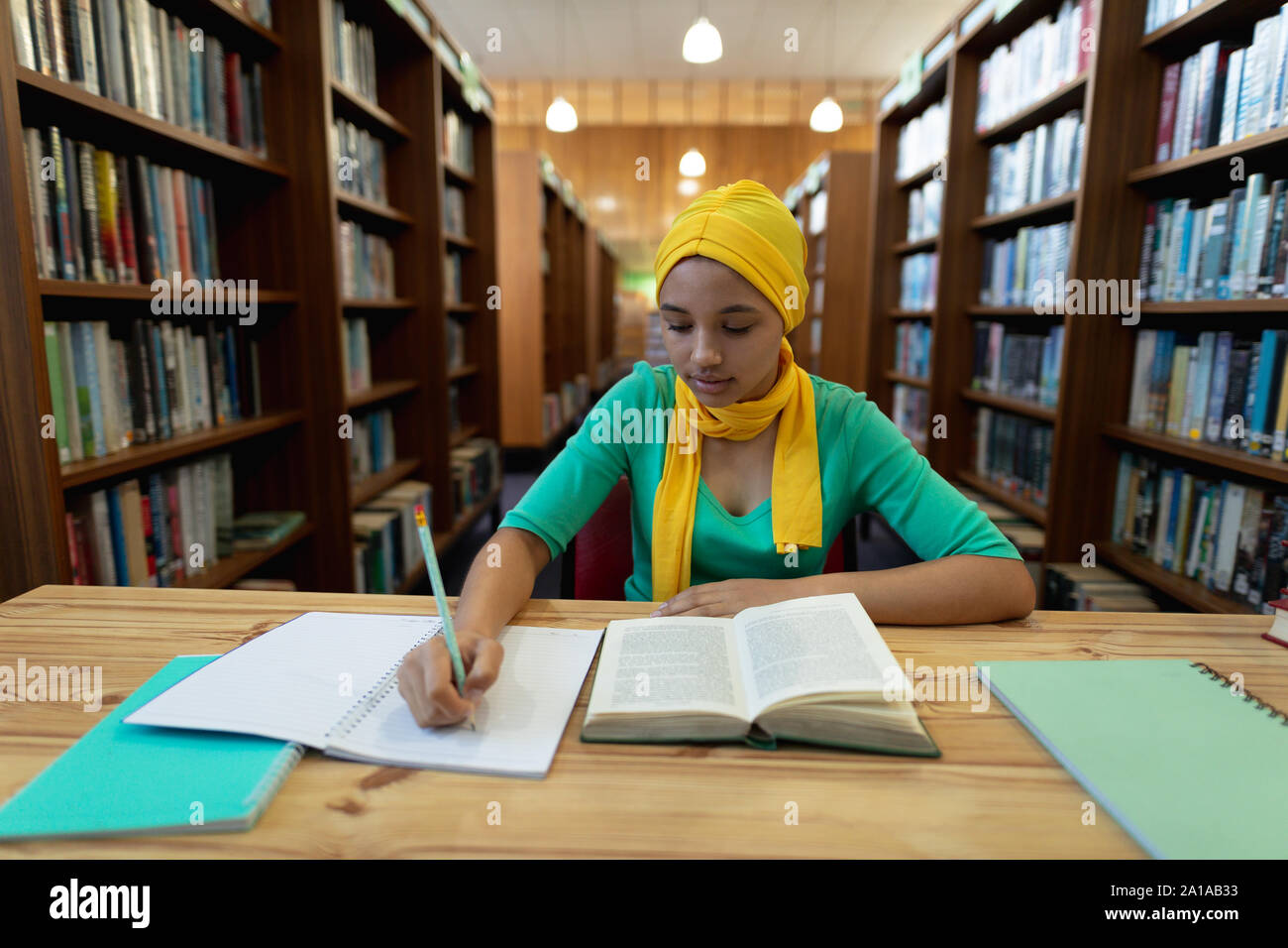 Young woman studying in library Stock Photo - Alamy